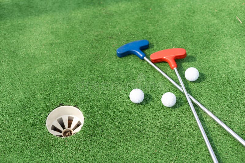 Mini-golf Clubs and Balls of Different Colors Laid on Artificial Grass ... Mini-golf Clubs and Balls of Different Colors Laid on Artificial Grass ...