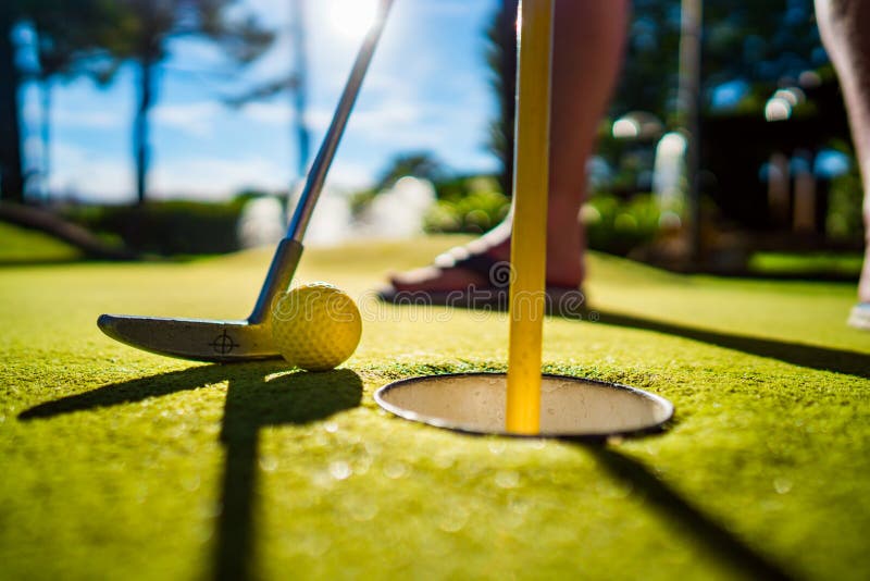 Mini Golf Yellow Ball with a Bat Near the Hole at Sunset Stock Photo ...