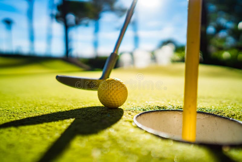 Mini Golf Yellow Ball with a Bat Near the Hole at Sunset Stock Photo ...