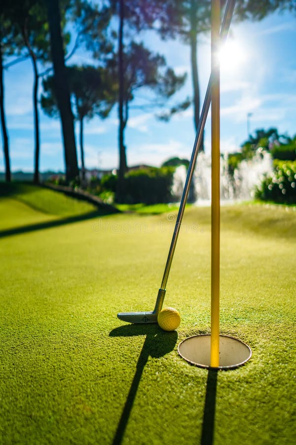 Mini Golf Yellow Ball with a Bat Near the Hole at Sunset Stock Photo ...