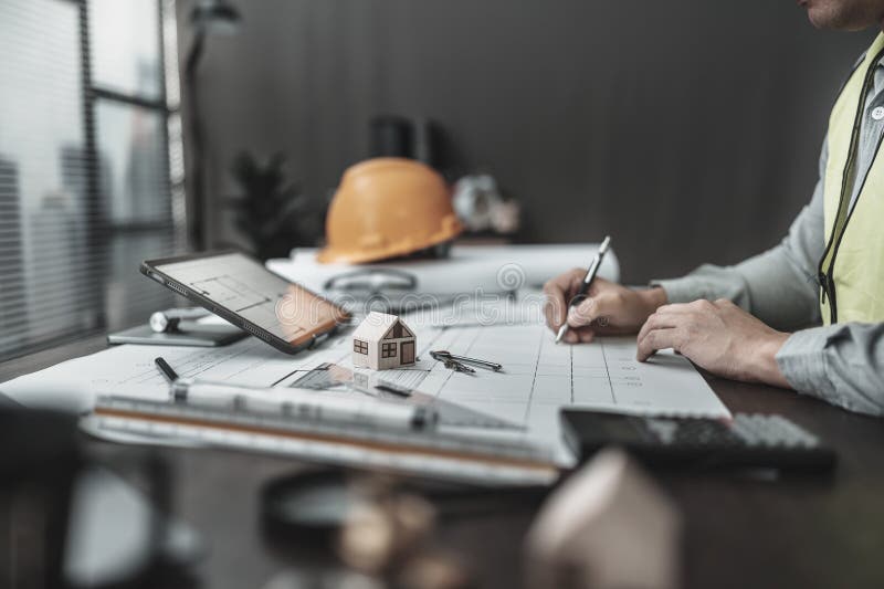 Mini House Model in Front of Architect Engineer Working on Blueprint ...