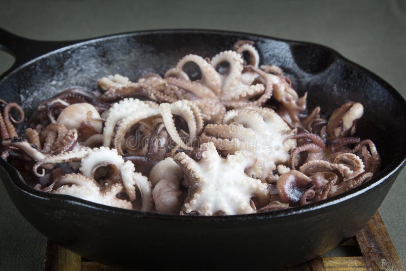 Mini Octopus in the Process of Roasting on a Cast Iron Pan Stock Photo ...