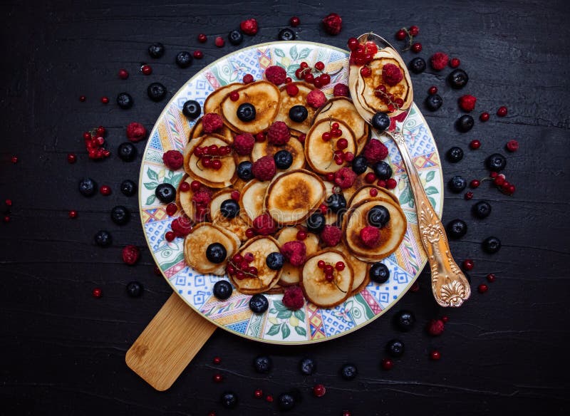 Mini Pancakes with Berries on a Patterned Plate with Silver Spoon in ...