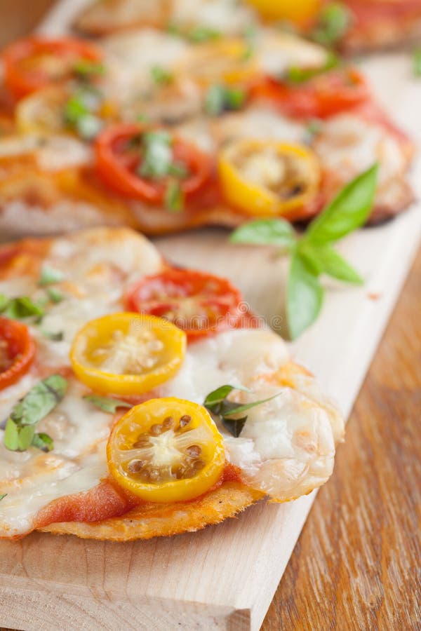 Mini Pizzas with Mozzarella, Cherry Tomatoes and Basil Stock Photo ...