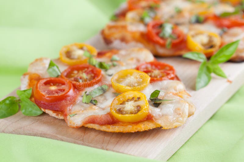Mini Pizzas with Mozzarella, Cherry Tomatoes and Basil Stock Image ...
