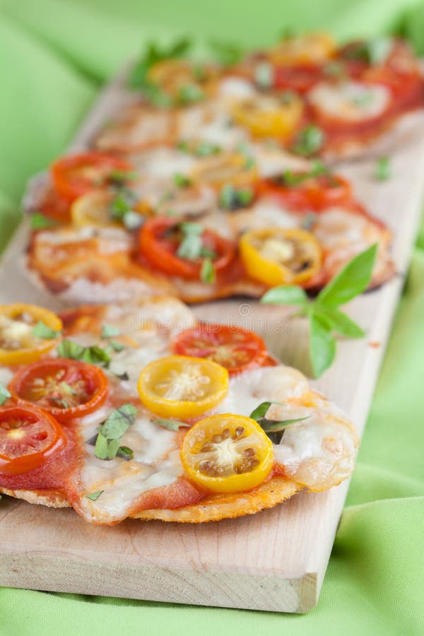 Mini Pizzas with Mozzarella, Cherry Tomatoes and Basil Stock Photo ...