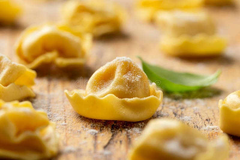 Mini Raw Ravioli with Flour and Basil on Wooden Board Stock Image ...
