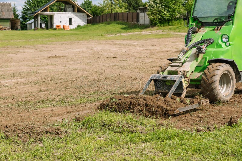 Mini Skid Steer Loader Clear a Construction Site. Small Tractor with a ...
