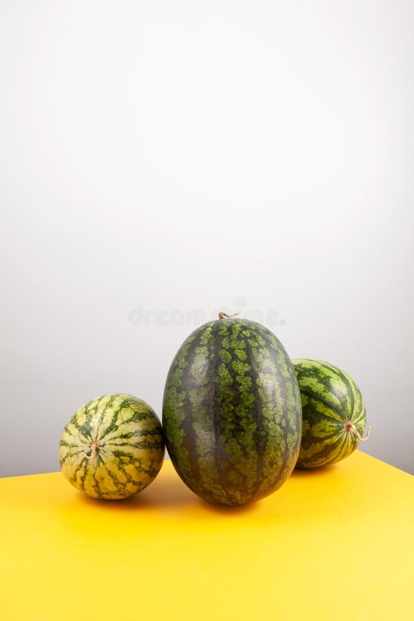 Mini Watermelons on Yellow Table. Three Ripe Watermelons of Different ...