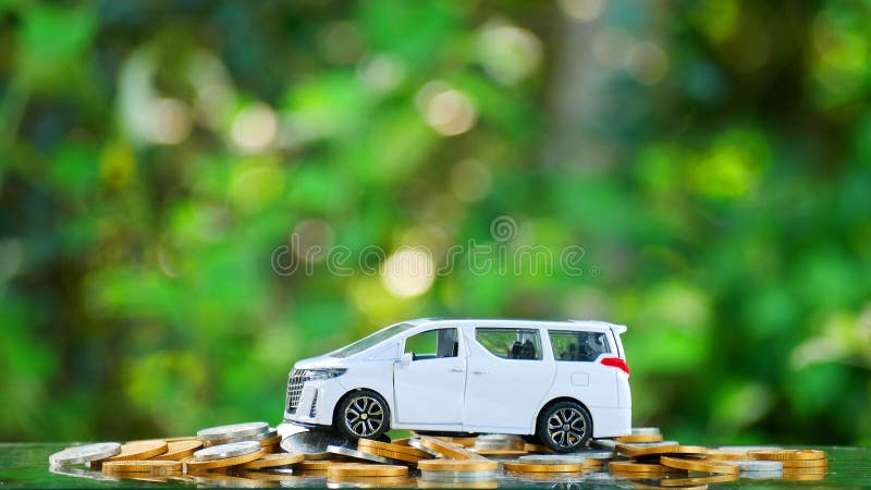 Miniature Car Crossing the Road of Stacks of Coins with Blurred Forest ...