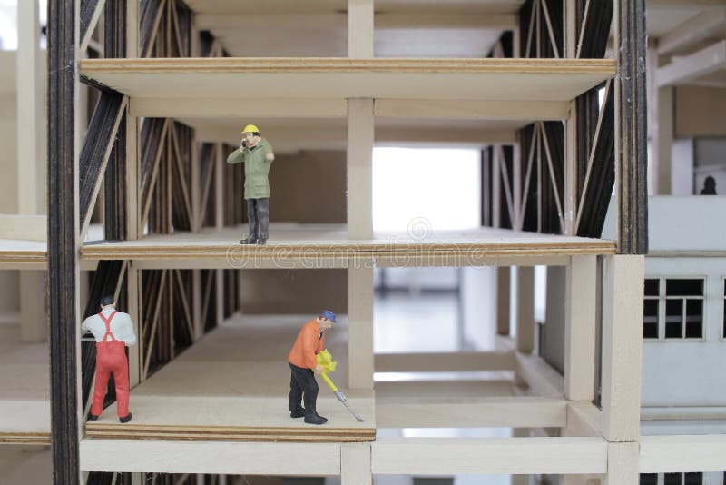 The Miniature Construction Workers Building Plans Stock Photo - Image ...