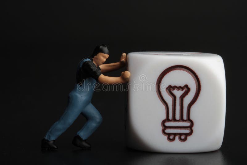 Miniature Figurine of a Man Pushing the Symbol of Idea Stock Photo ...