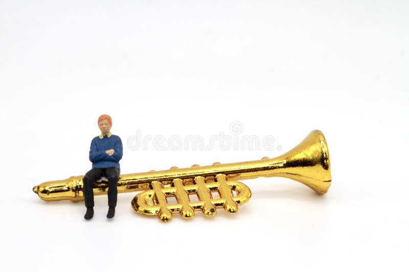 Miniature Figurine of a Man Sitting on a Trumpet Stock Image - Image of ...