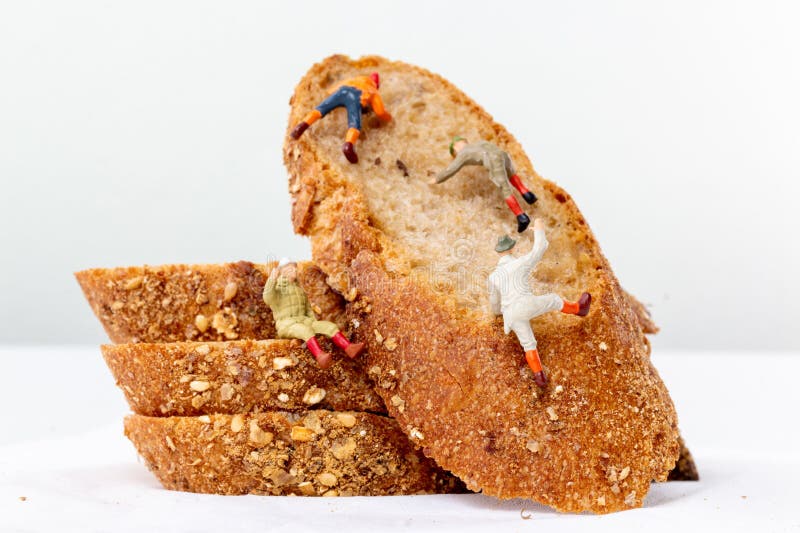 Miniature Figurines Climbing a Stack of Multigrain Bread Slices ...