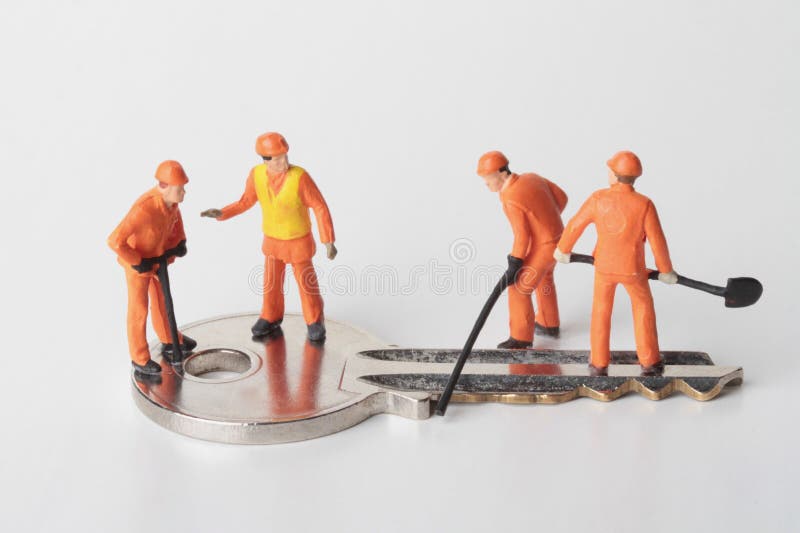 Miniature Figurines of Men at Work with a Giant Key Stock Photo - Image ...