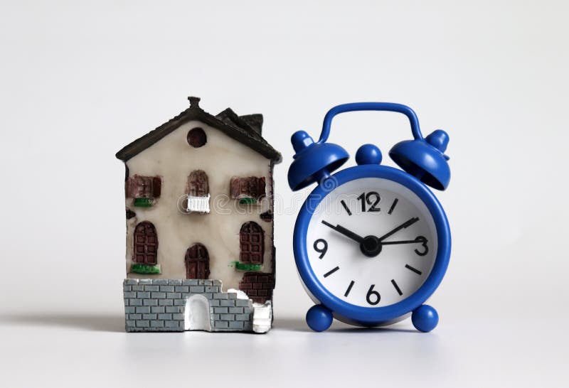 A Miniature House and a Blue Alarm Clock. Stock Photo - Image of market ...