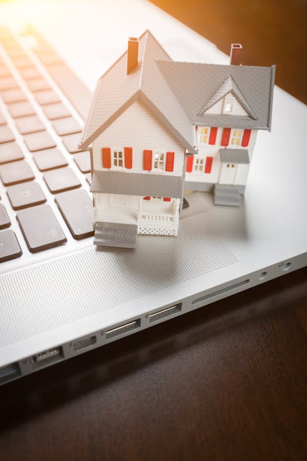 Miniature House and Laptop Computer Resting on Desktop. Stock Image ...