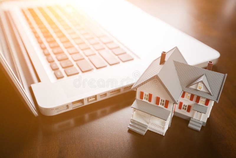 Miniature House and Laptop Computer Resting on Desktop. Stock Image ...