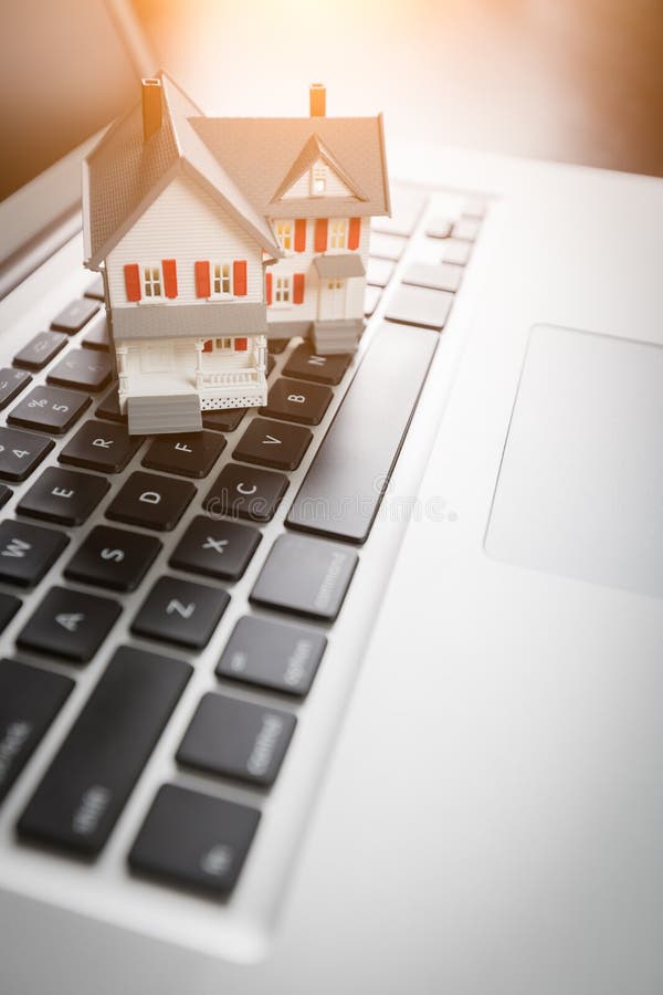 Miniature House and Laptop Computer Resting on Desktop. Stock Image ...