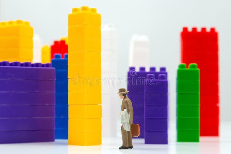 Miniature People. Figures of People Stand Near the Colored Blocks of a ...
