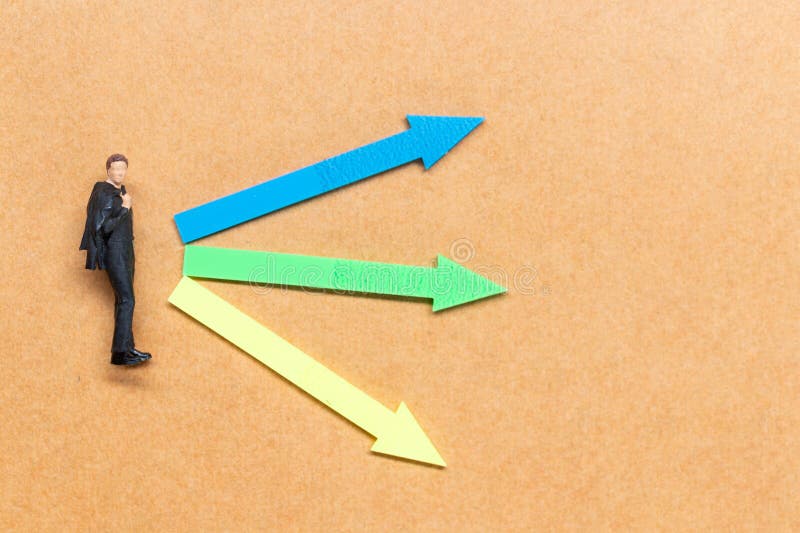A Miniature People Stands at the Intersection of Colorful Arrows on a ...