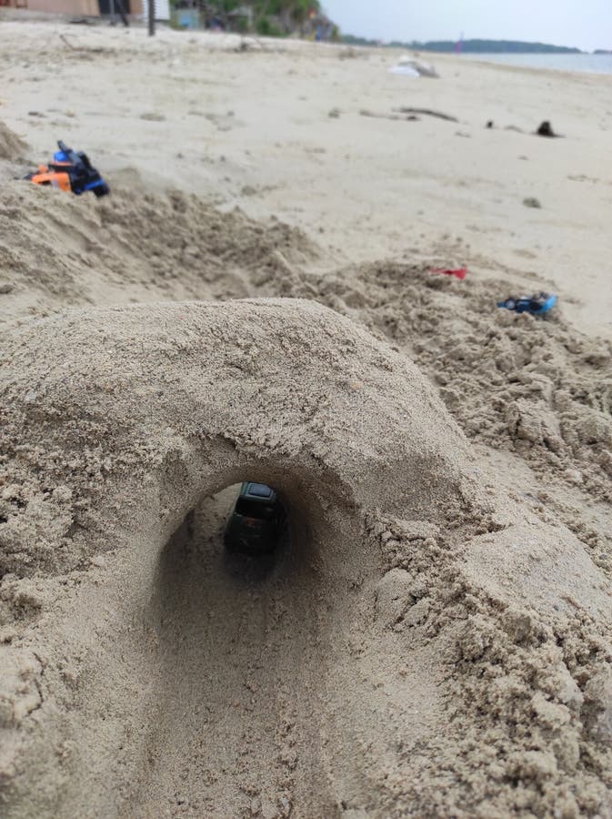 A Miniature Tunnel Made of Compacted Beach Sand with Some Toys Around ...