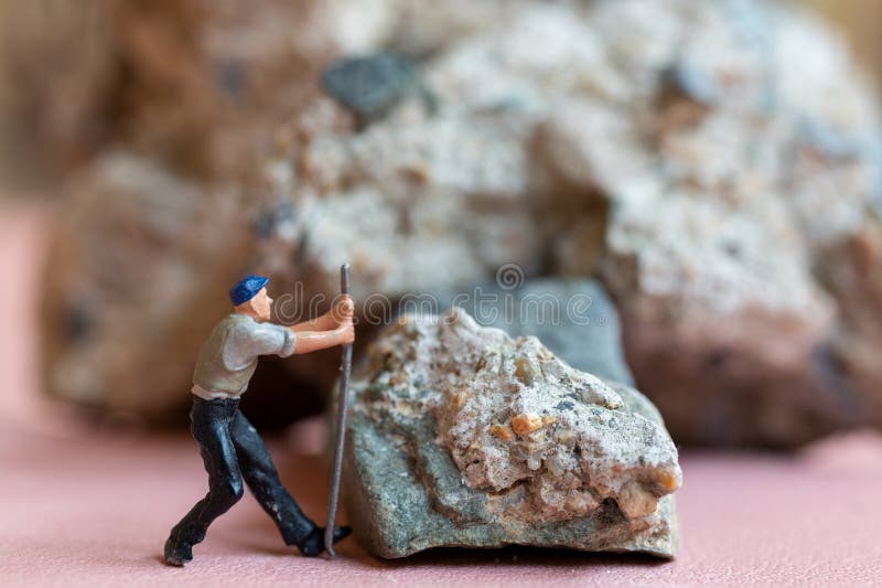 Miniature Worker Pushing a Large Rock. Themes of Perseverance, Strength ...