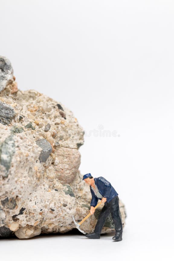 Miniature Worker Using a Pickaxe To Chip Away at a Large Rock Stock ...