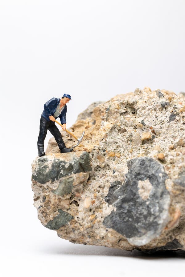 Miniature Worker Using a Pickaxe To Chip Away at a Large Rock Stock ...