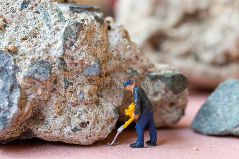 A Miniature Worker Worker Drilling a Big Rock . Themes of Perseverance ...