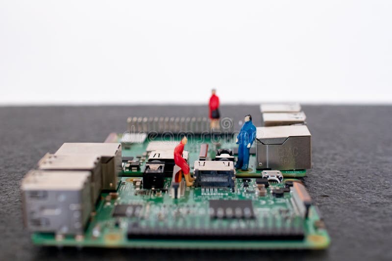 Miniatures of People on a Green Electronic Board. Relationship between ...