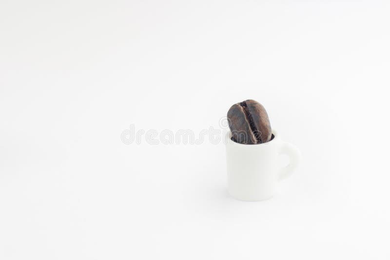 Miniautre White Coffee Cup with a Coffee Bean Inside Isolated on a ...