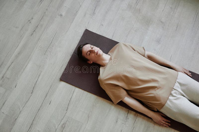 Top View at Young Man Lying Down on Floor in Meditation with Eyes ...