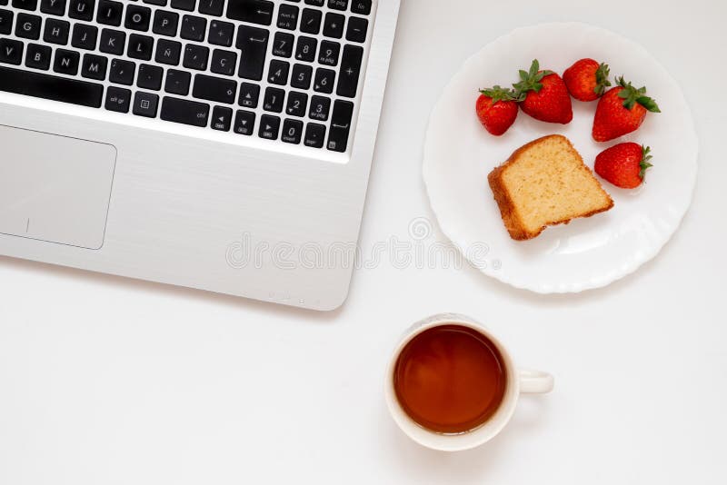 Minimal Workspace: Laptop with Tea and Breakfast, Strawberries with ...