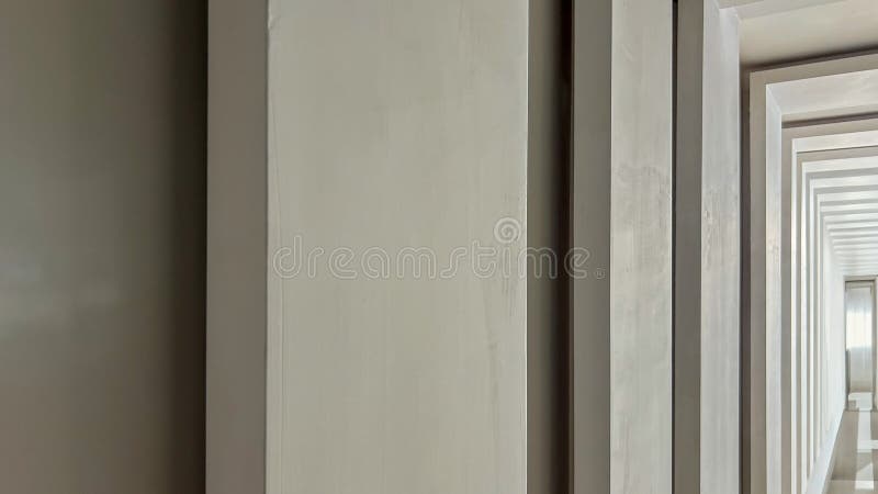 Minimalist Architectural Hallway with Repeating White Columns and Soft ...