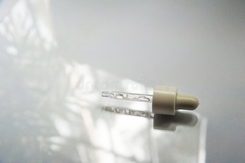 Minimalist Dropper with Transparent Liquid on White Background. Stock ...