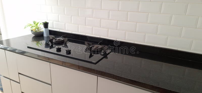 Minimalist Kitchen with Cooktop and Black Granite Table Stock Image ...