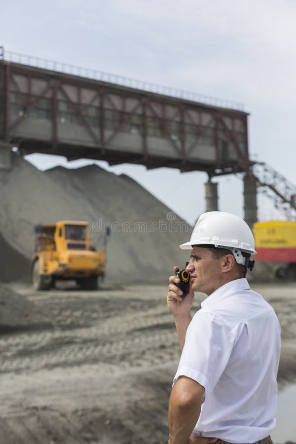 Mining Engineer in White Shirt and Helmet Supervises Loading Dumpers in ...