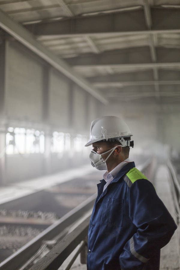 Mining Engineer in White Helmet and Respirator Inspects Dusty Dirty ...