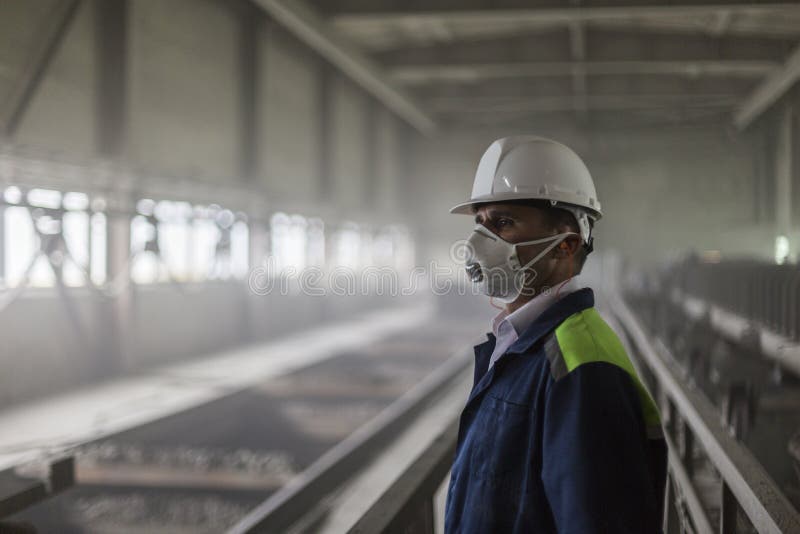 Mining Engineer in White Helmet and Respirator Inspects Dusty Dirty ...