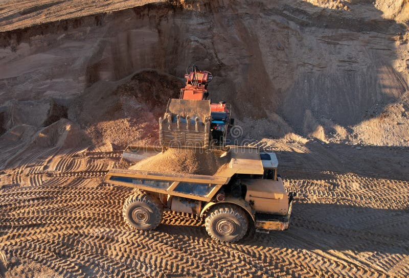 Mining Excavator Load the Sand into Dump Truck in Open Pit. Developing ...