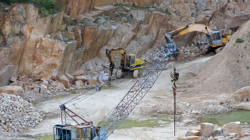 Mining in the Granite Quarry. Working Mining Machine - Old Crane and ...