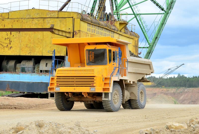 Mining Truck and Excavators Working in the Limestone Open-pit. Loading ...