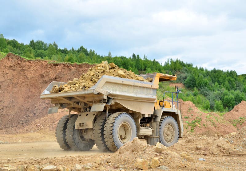 Mining Truck and Excavators Working in the Limestone Open-pit. Loading ...