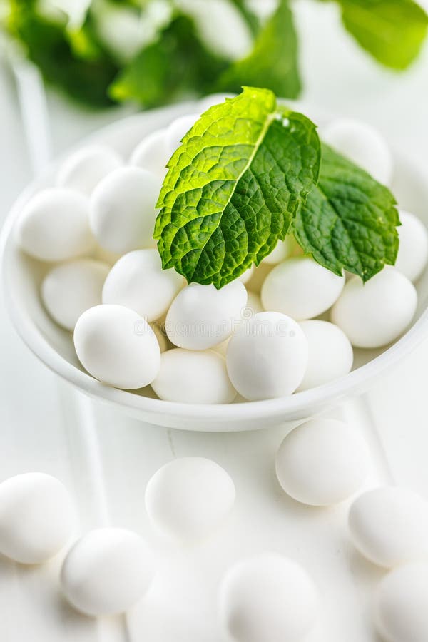 Mint Candies in Bowl. Menthol Bonbons and Mint Leaves on White Table ...