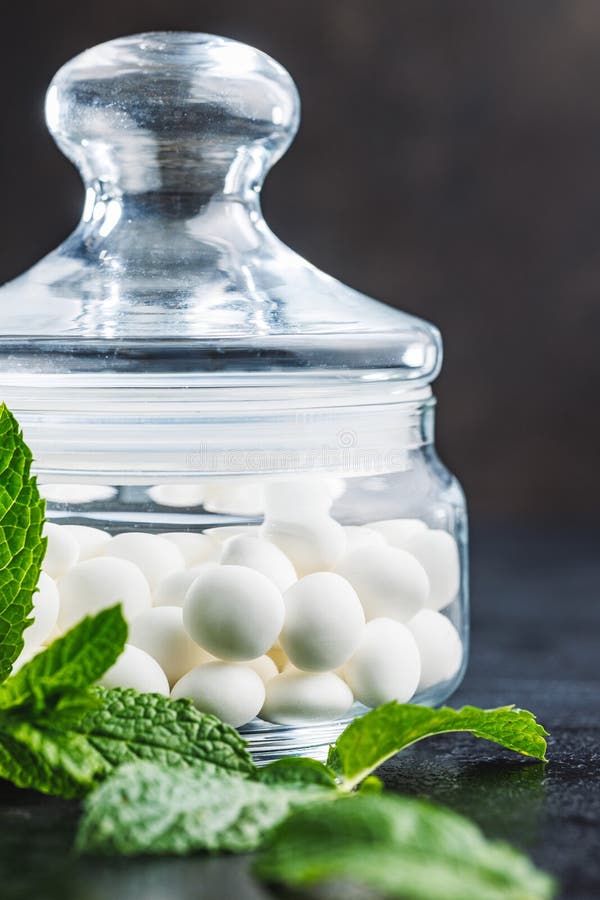 Mint Candies in Jar. Menthol Bonbons and Mint Leaves on Black Table ...