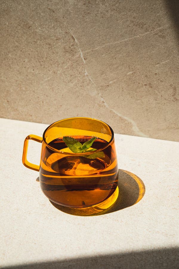 Mint Tea in an Orange Glass Mug on a Light Stone Table Stock Photo ...