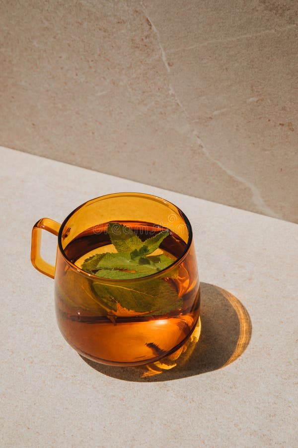 Mint Tea in an Orange Glass Mug on a Light Stone Table Stock Image ...