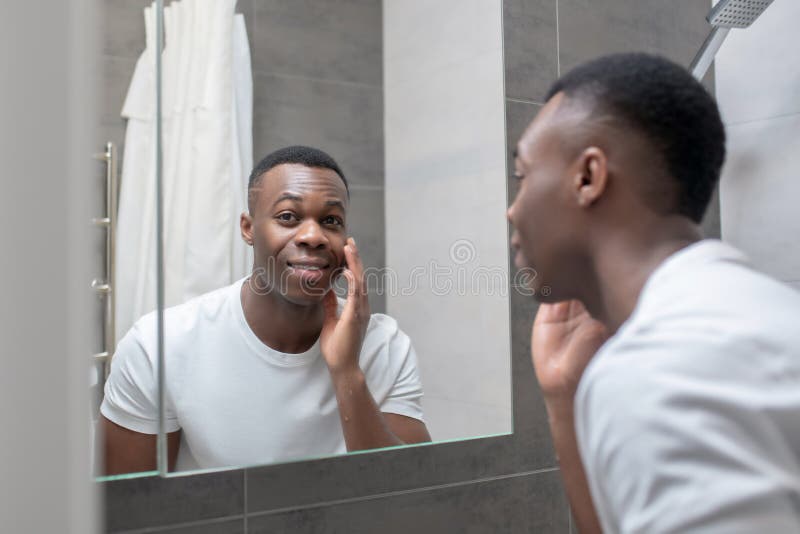 African American Young Handsome Man Looking at Himself in the Mirror ...