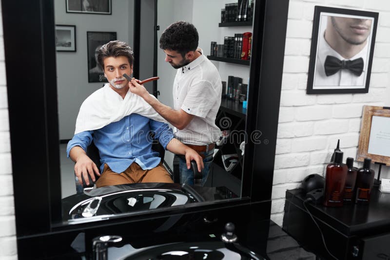 Through a Mirror, Barber Serves Customers in Salon Stock Image - Image ...
